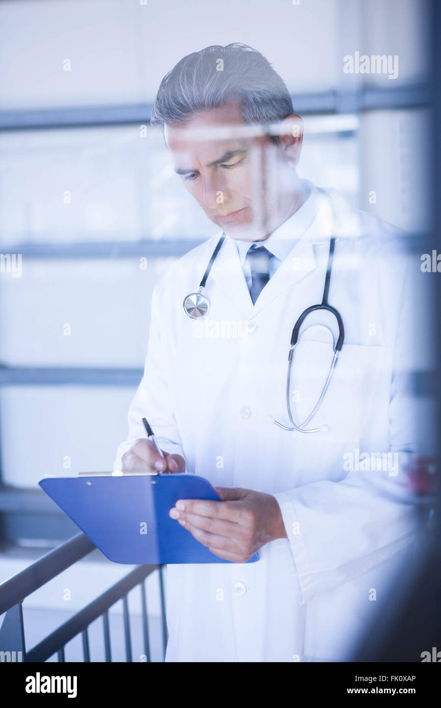 Male doctor writing on clipboard Stock Photo - Alamy