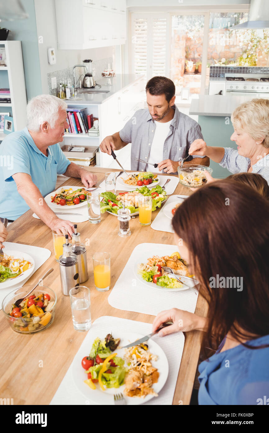 Family sitting at dining table Stock Photo - Alamy