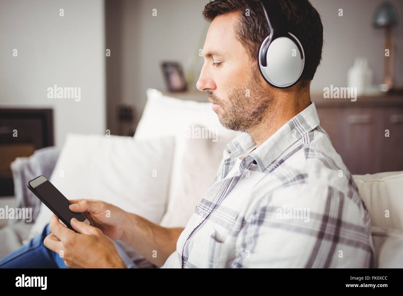 Man using mobile phone while wearing headphones Stock Photo - Alamy