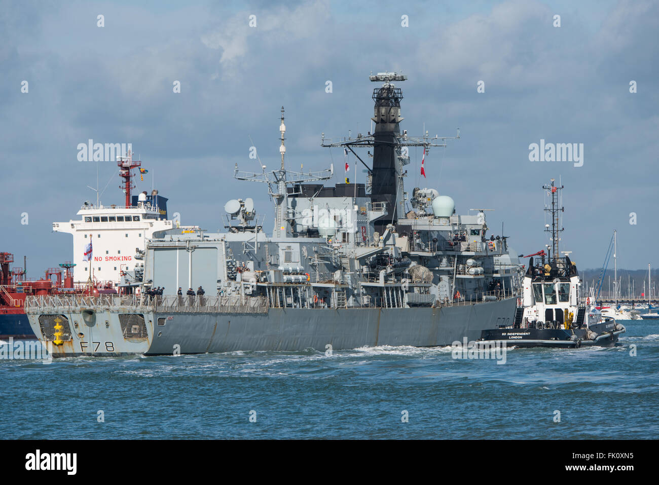 HMS Kent (F78) being assisted by a tug in Portsmouth Harbour Stock ...