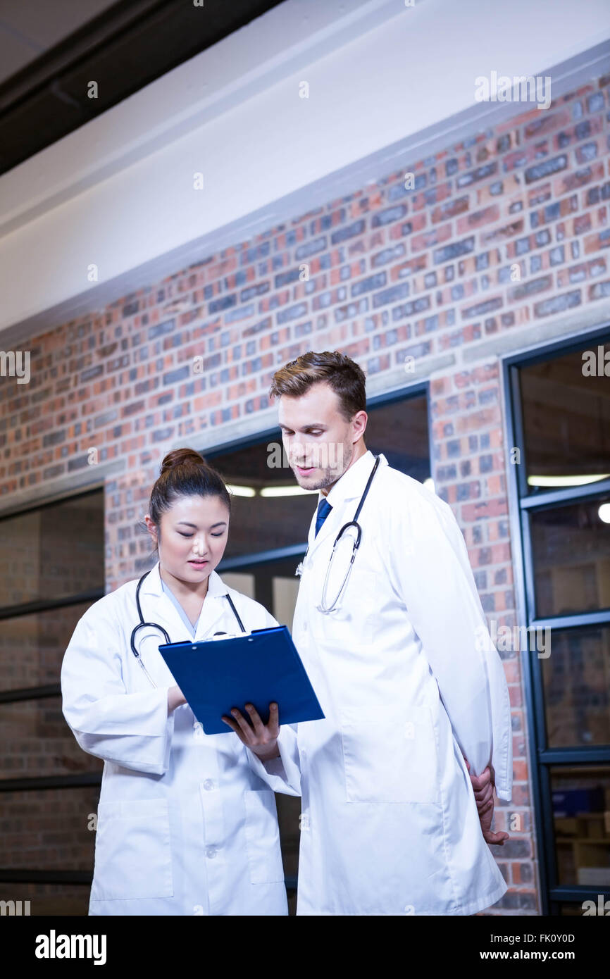 Two doctors looking at clipboard and discussing near library Stock ...