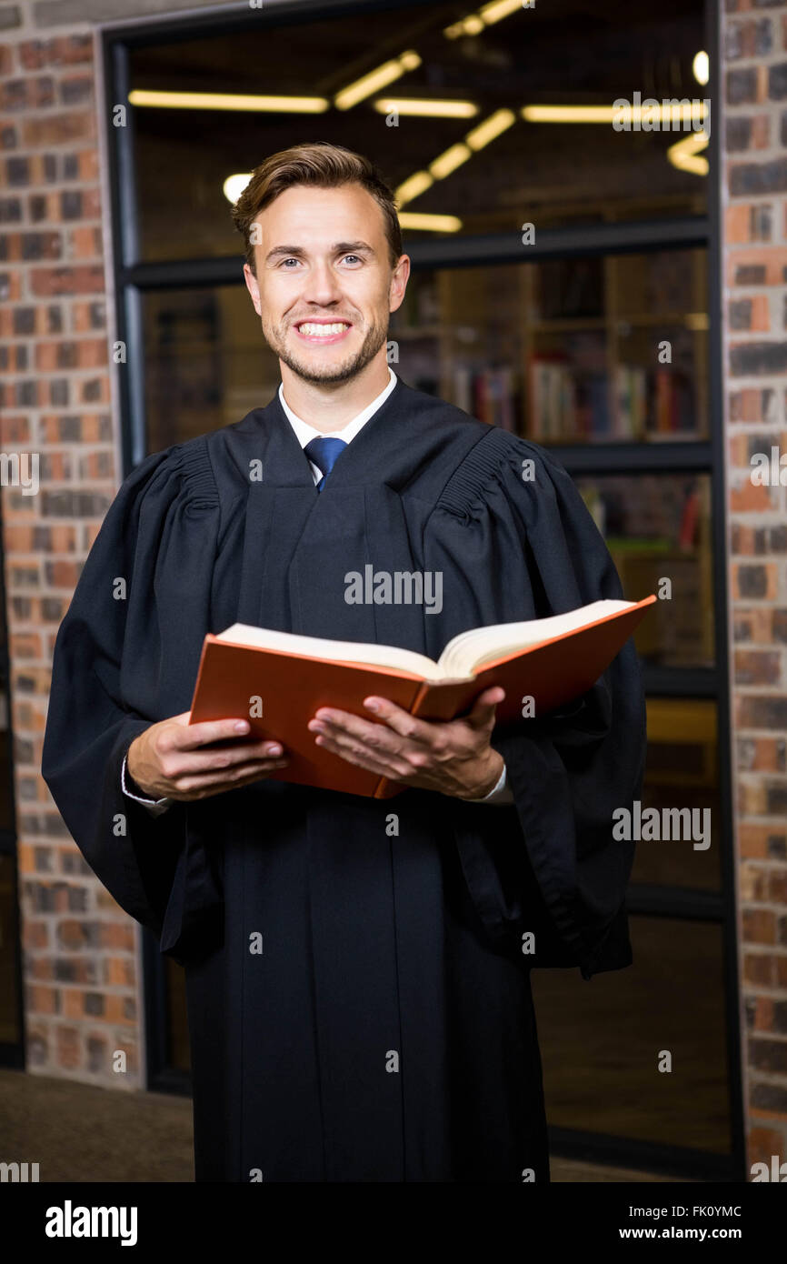 Lawyer standing near library with law book Stock Photo - Alamy
