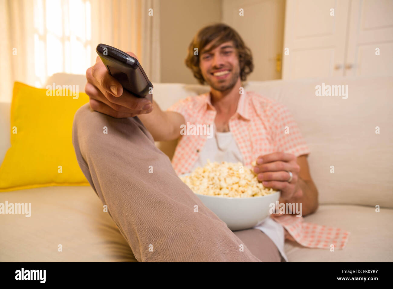 Handsome man watching TV and eating pop corn Stock Photo - Alamy