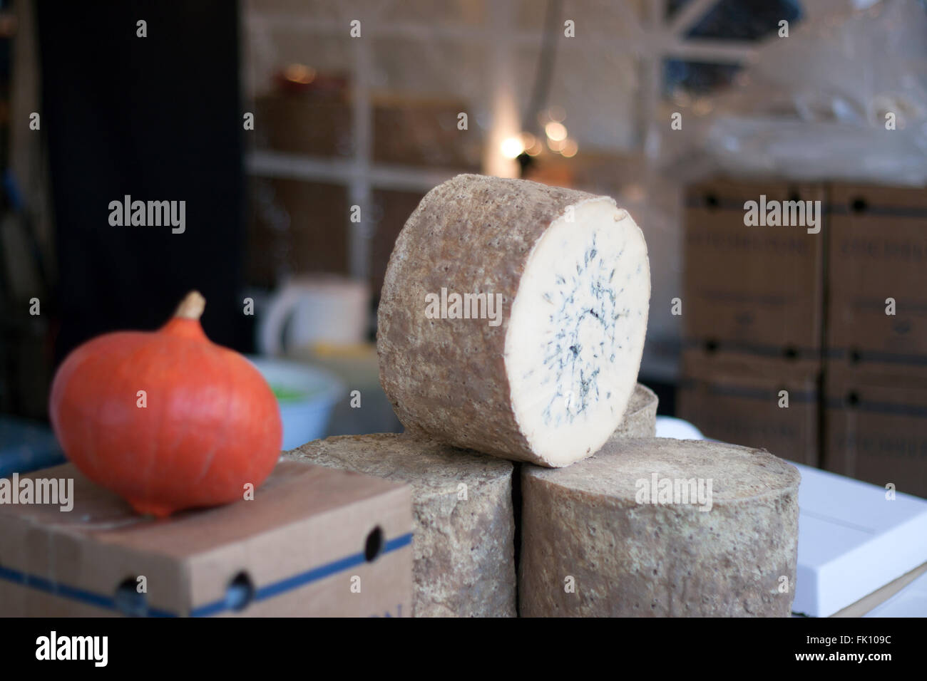Stack of cheese wheels and a red gourd on display Stock Photo - Alamy