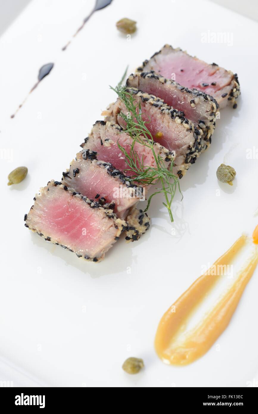 Ahi Tuna Seared on a white plate Stock Photo - Alamy