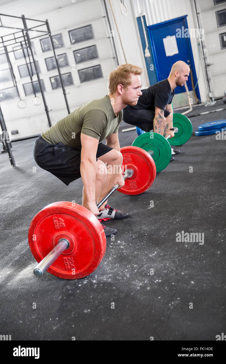 Two men train deadlift at fitness gym center Stock Photo - Alamy