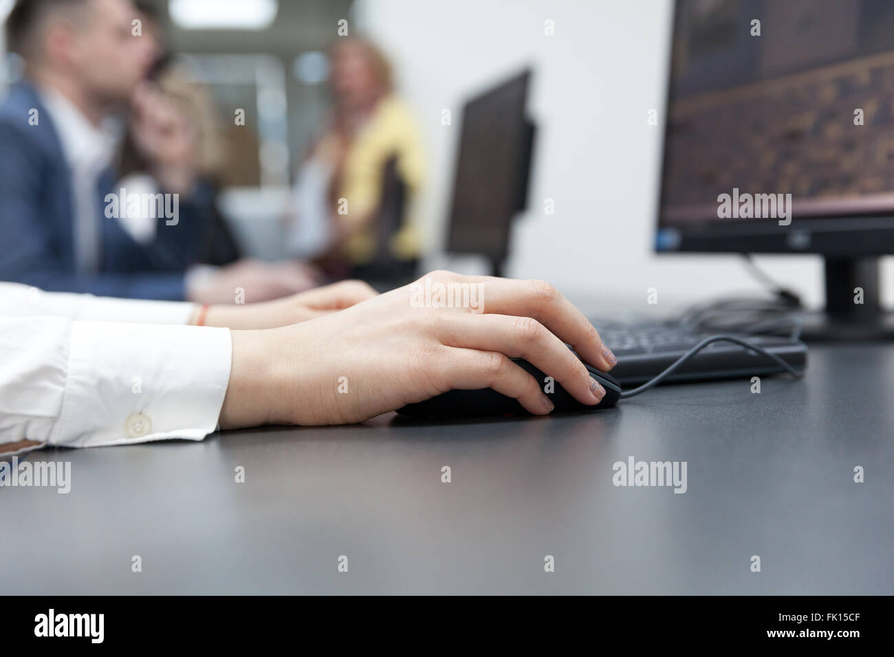Close up of female hand on mouse while typing on keyboard Stock Photo ...