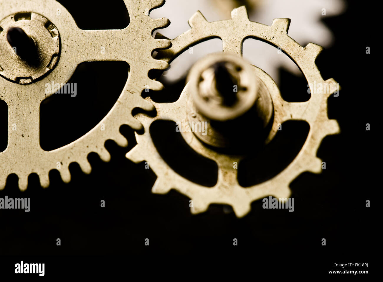 Horizontal macro photography of three golden clock wheels on black ...