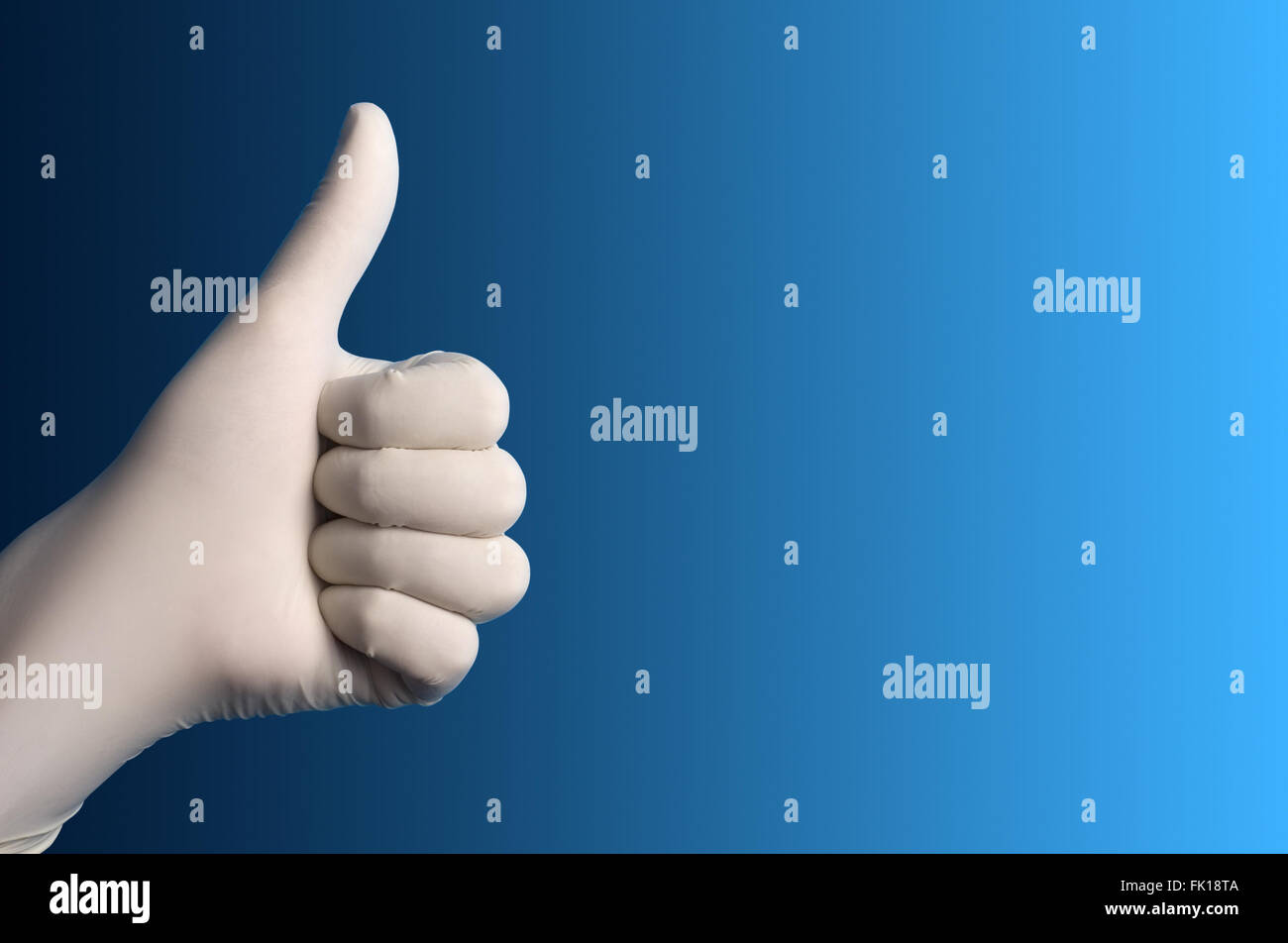 Hand with a white surgical glove showing the ok sign against a blue ...