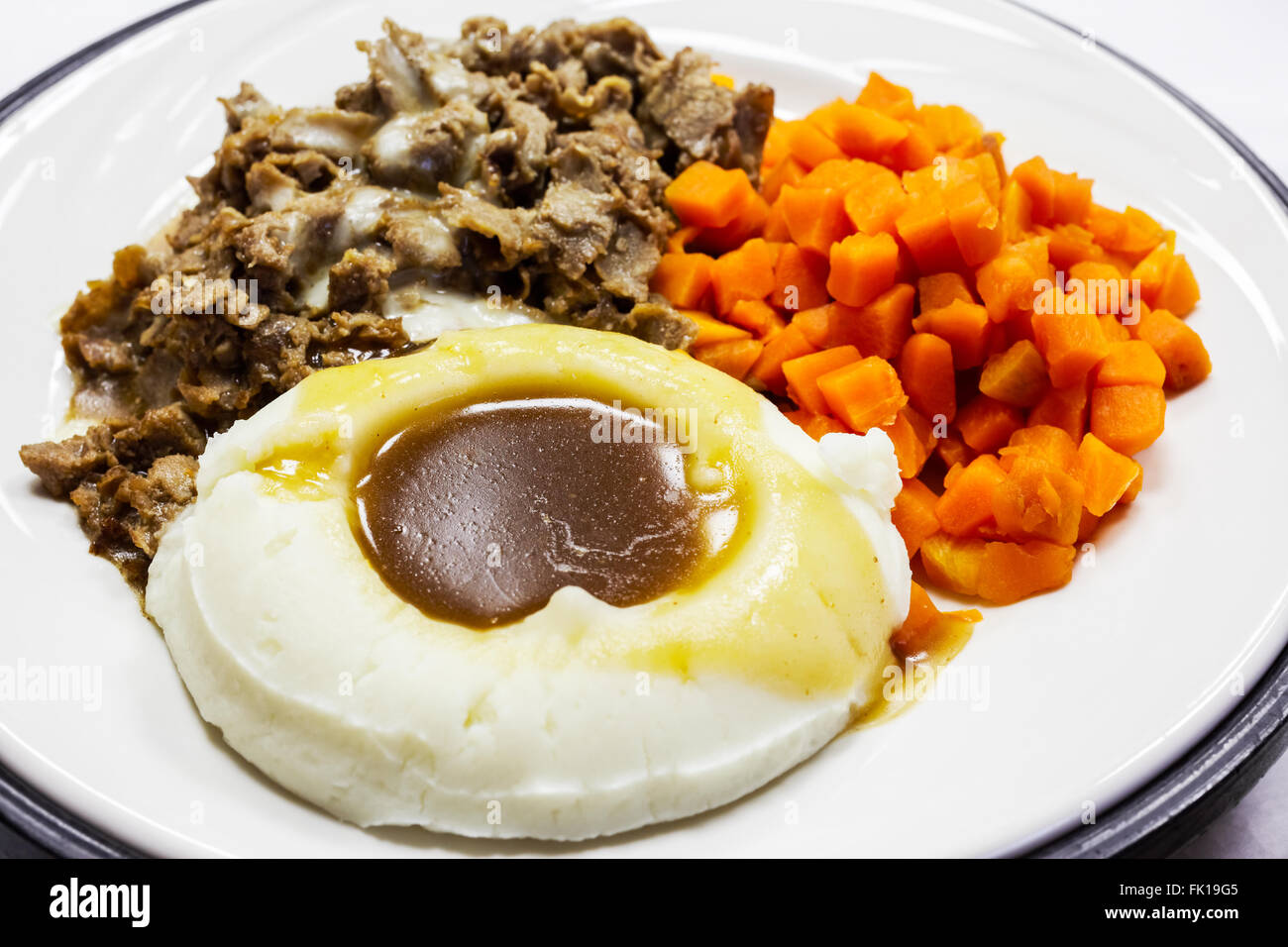 Plate of hospital food with beef, chopped carrots, mashed potatoes ...