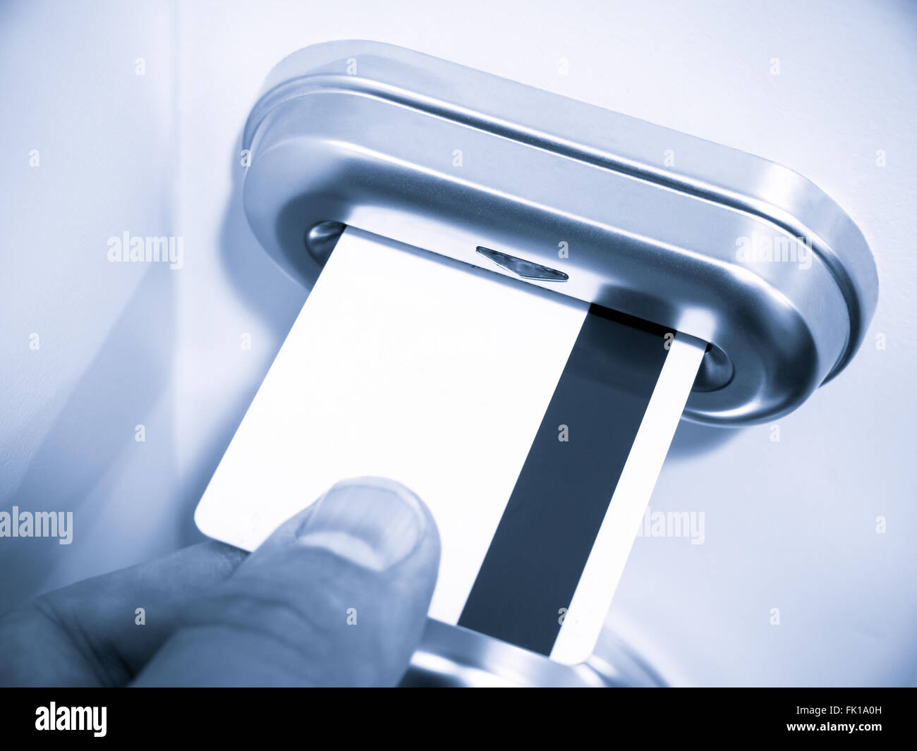 Person's hand inserting a magnetic stripe keycard into a hotel room ...