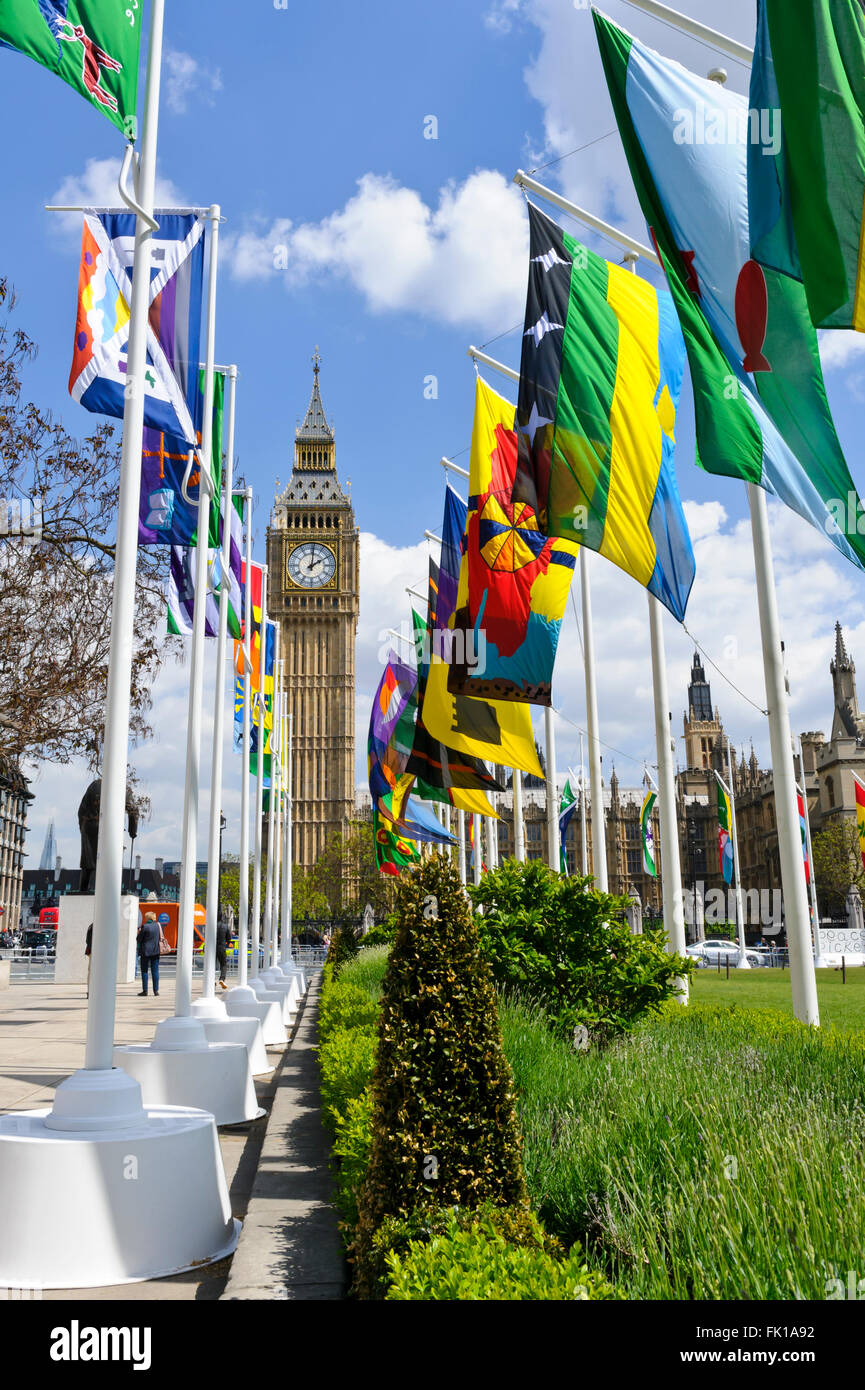 The iconic Big Ben tower among colourful international flags, London ...