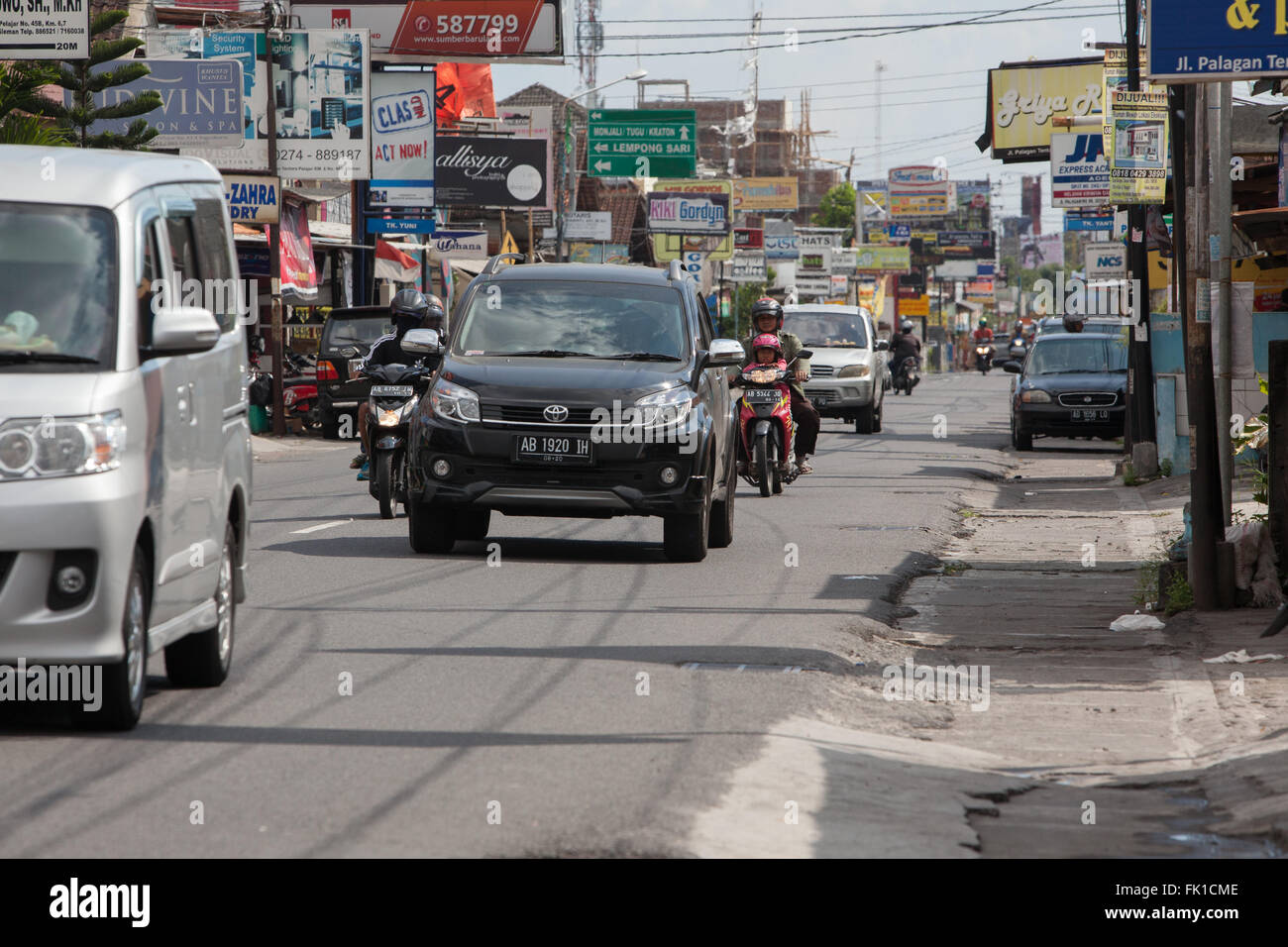 Typical Indonesian street scene: a reasonable road with lots of ...