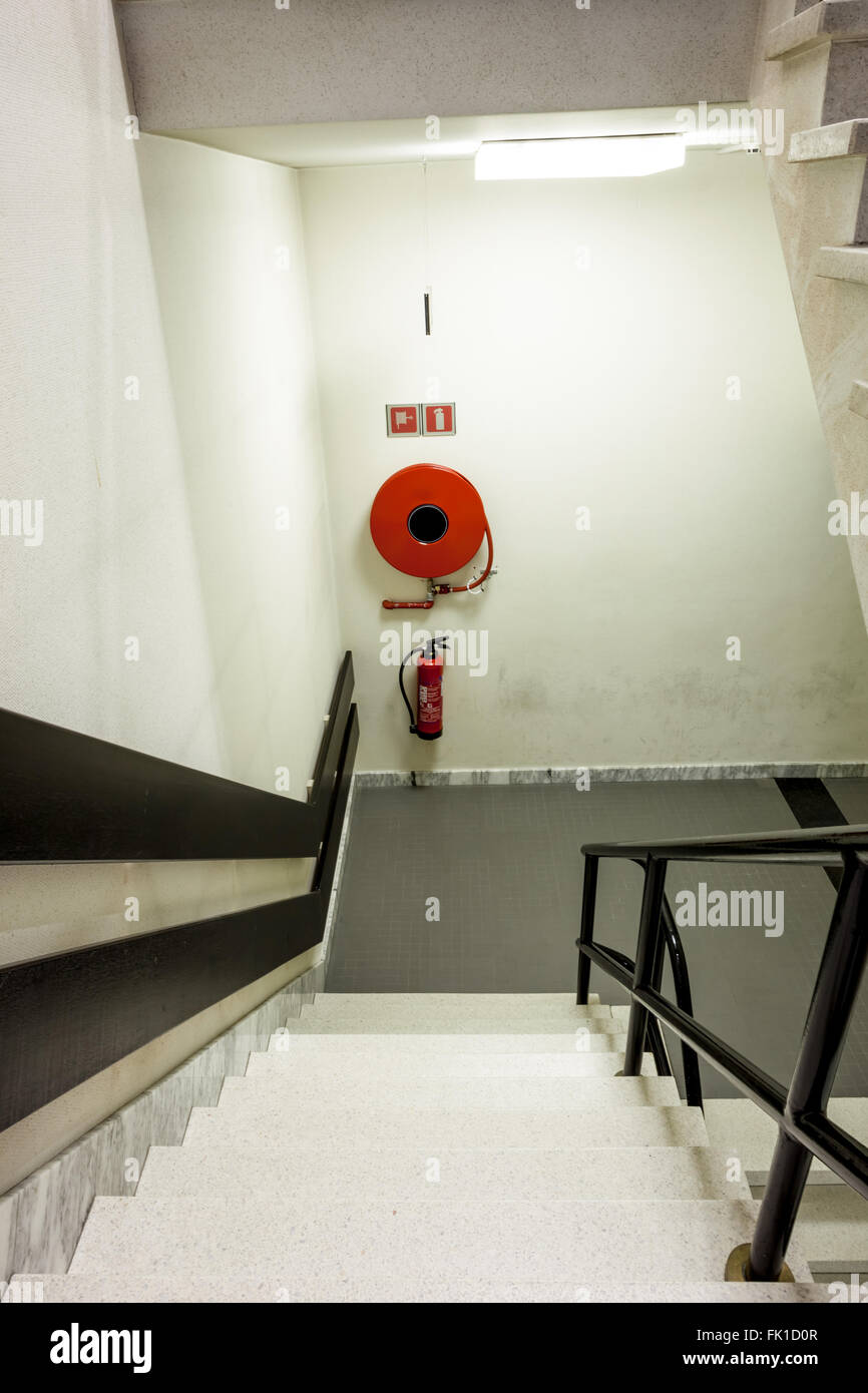 an fire hose hanging on the wall in an staircase Stock Photo - Alamy
