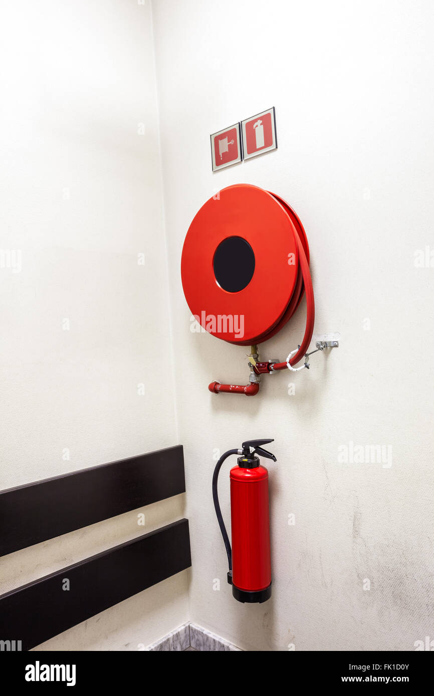 an fire hose hanging on the wall in an staircase Stock Photo - Alamy