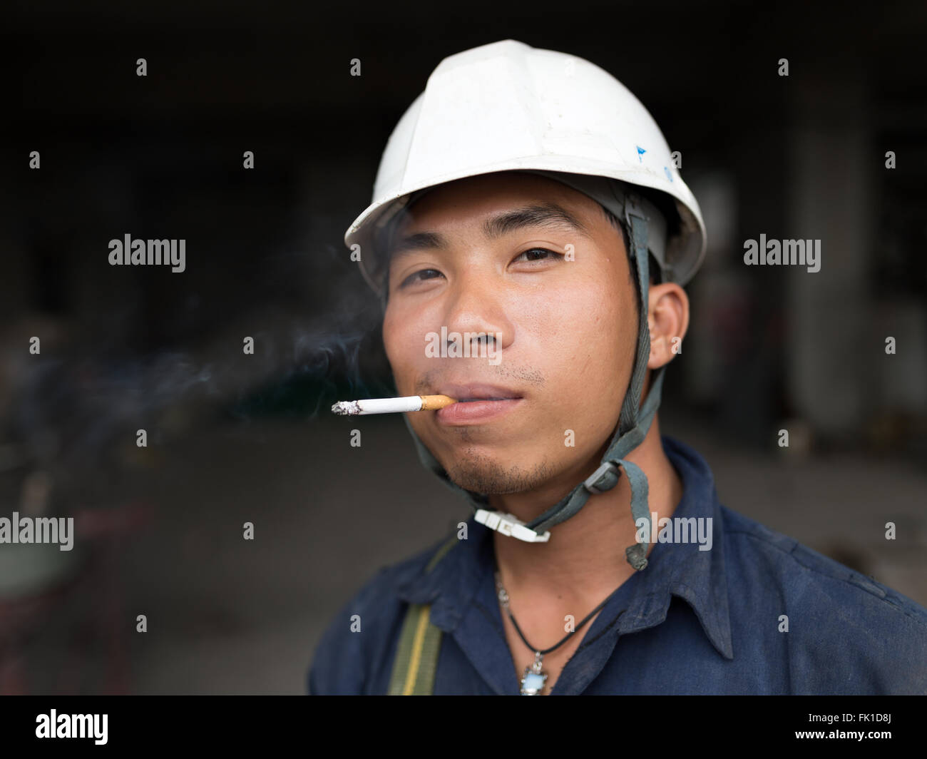 Portrait of a construction worker smoking a cigarette. Hanoi, Vietnam ...