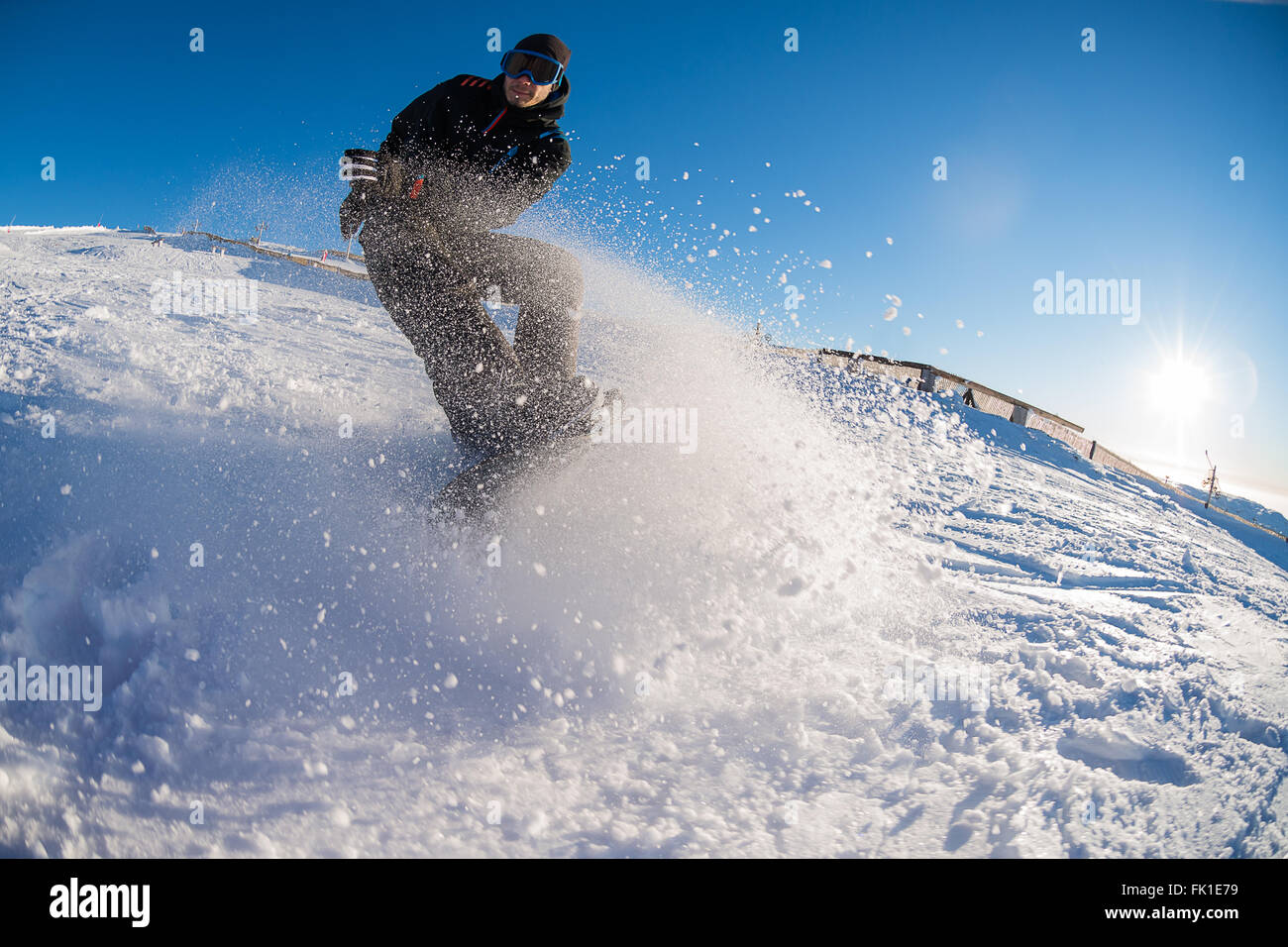 Snowboard freerider in the mountains against sun shine in blue sky ...