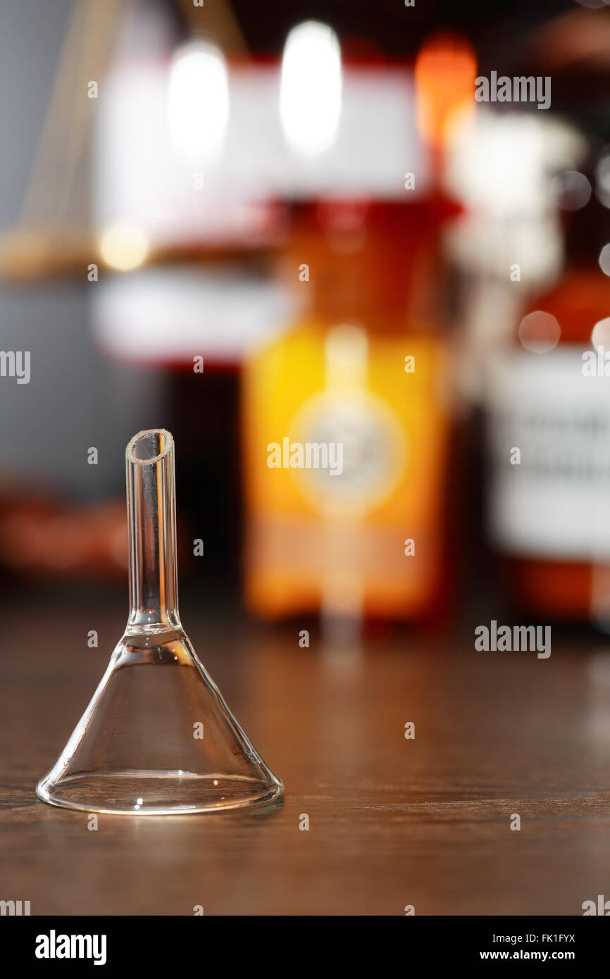 Chemical funnel against blurred background with flasks Stock Photo - Alamy