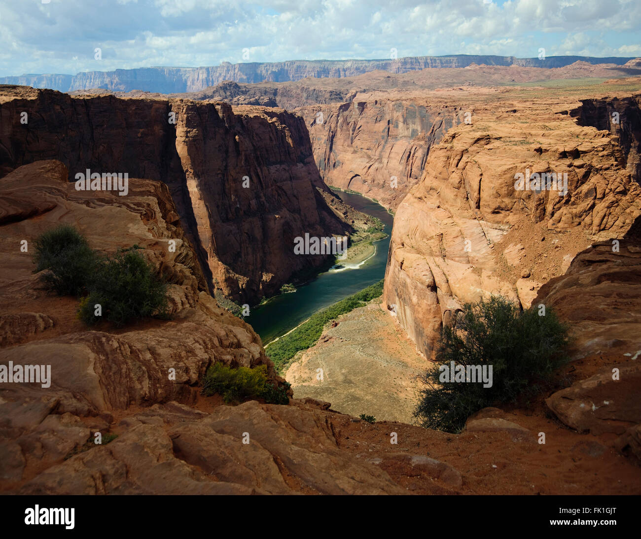 Colorado River just below Glenn Canyon Dam. The cliffs and foliage on ...