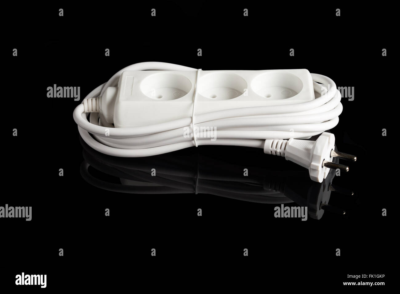 White plastic electrical outlet extension isolated on black reflecting ...