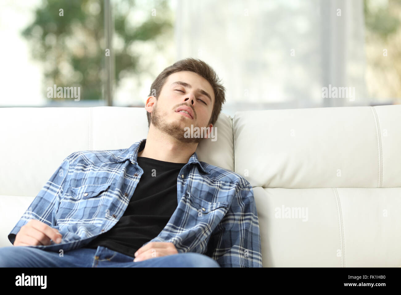 Front view of a tired man sleeping on a couch at home Stock Photo - Alamy