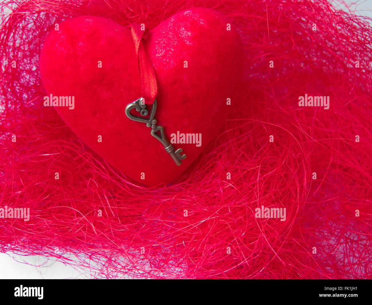 Red heart in the nest with bronze key Stock Photo - Alamy