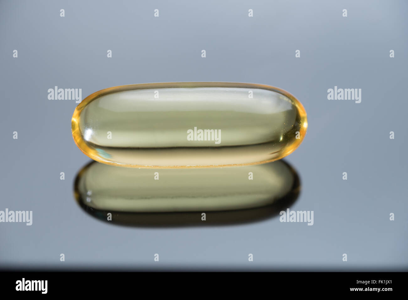 Cod liver oil capsule against a black background Stock Photo - Alamy