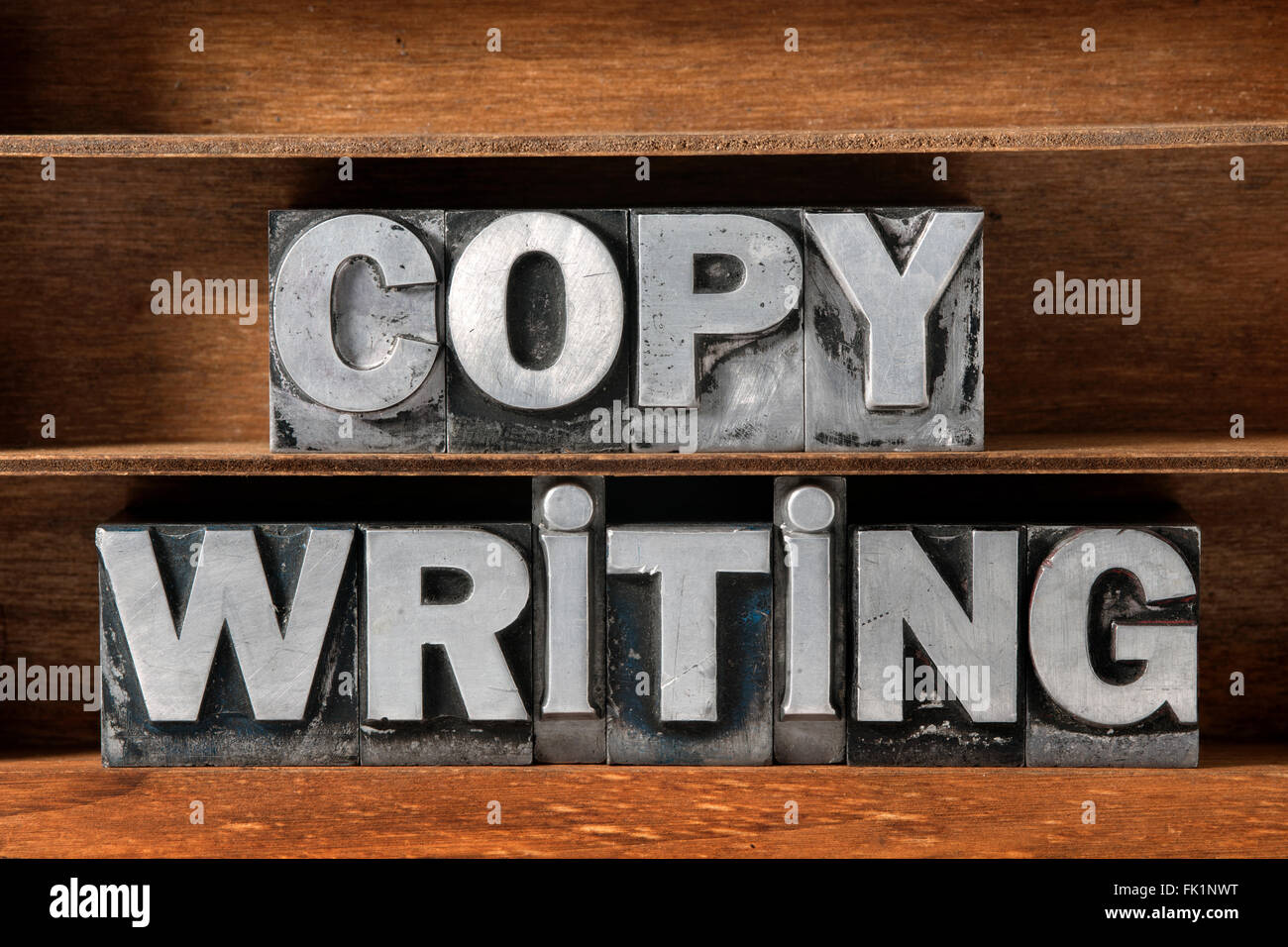 copy writing phrase made from metallic letterpress type on wooden tray ...