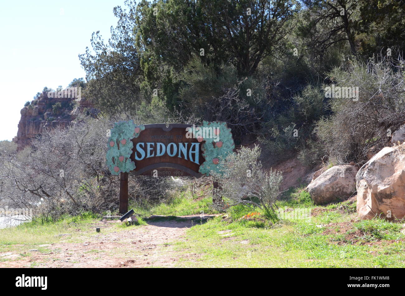 sedona welcome sign arizona with rocks trees bushes grass wooden sign ...