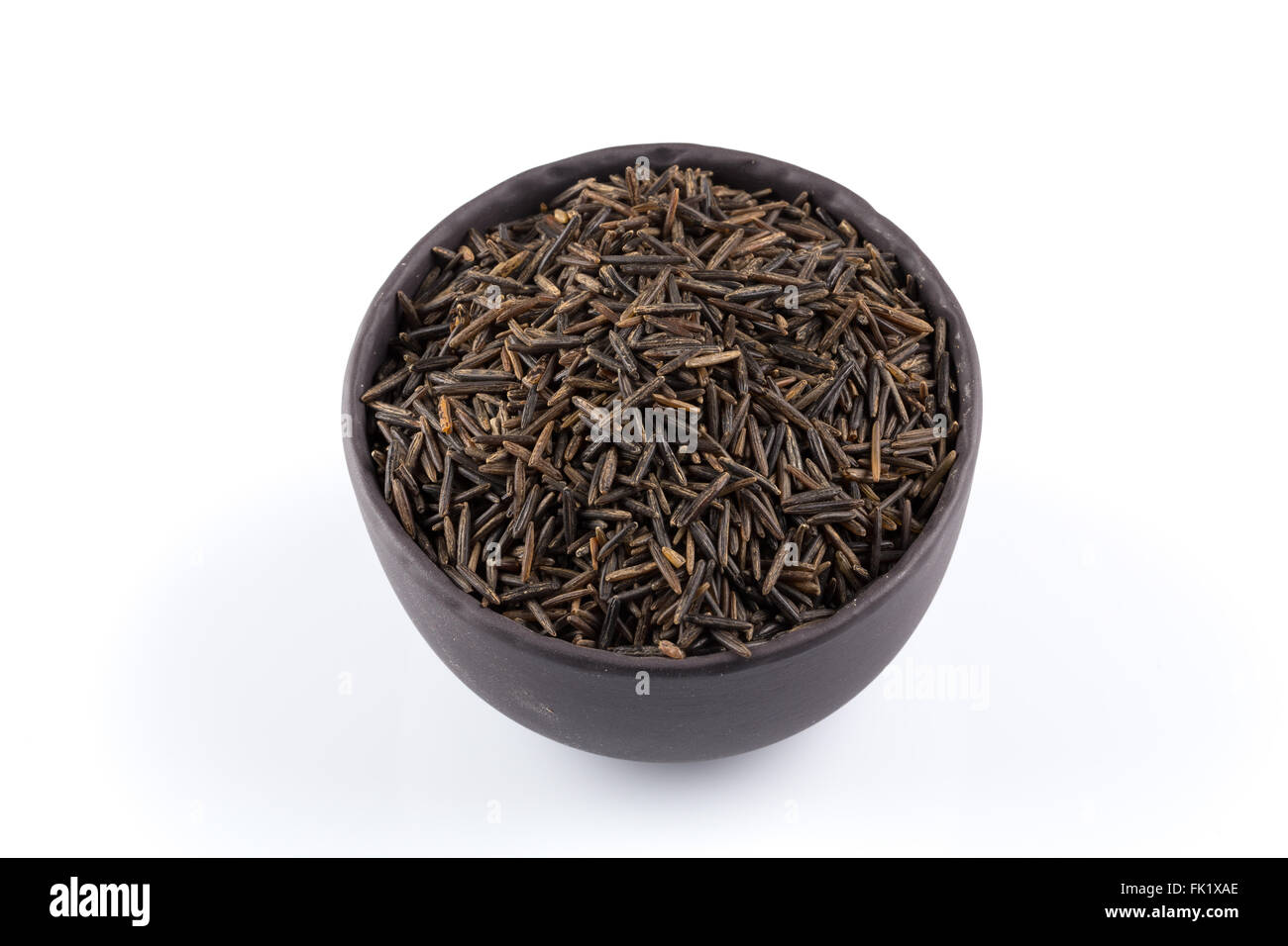 Wild brown rice in bowl and loose over white background Stock Photo - Alamy