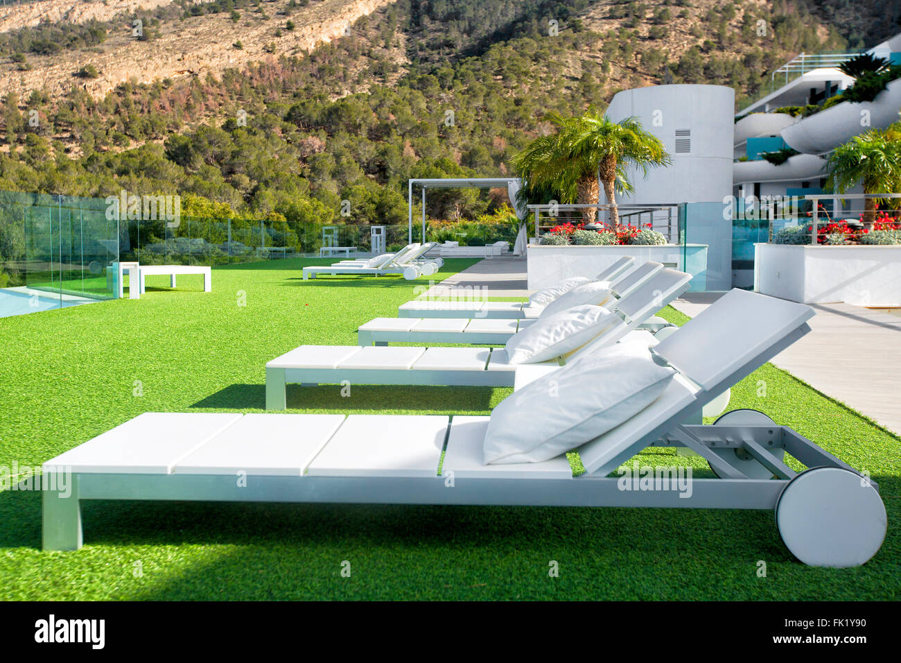 Swimming pool area with white sun beds at the modern resort Stock Photo ...