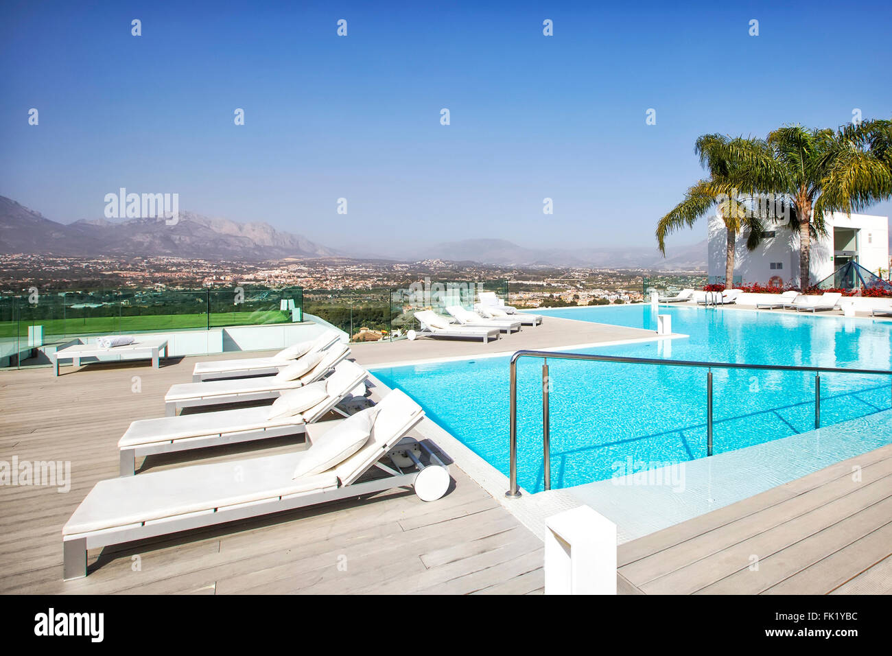 Swimming pool area with white sun beds at the modern resort Stock Photo ...