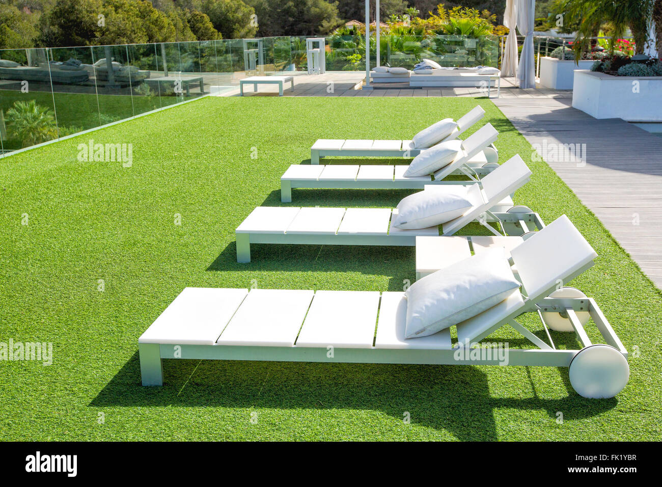 Swimming pool area with white sun beds at the modern resort Stock Photo ...