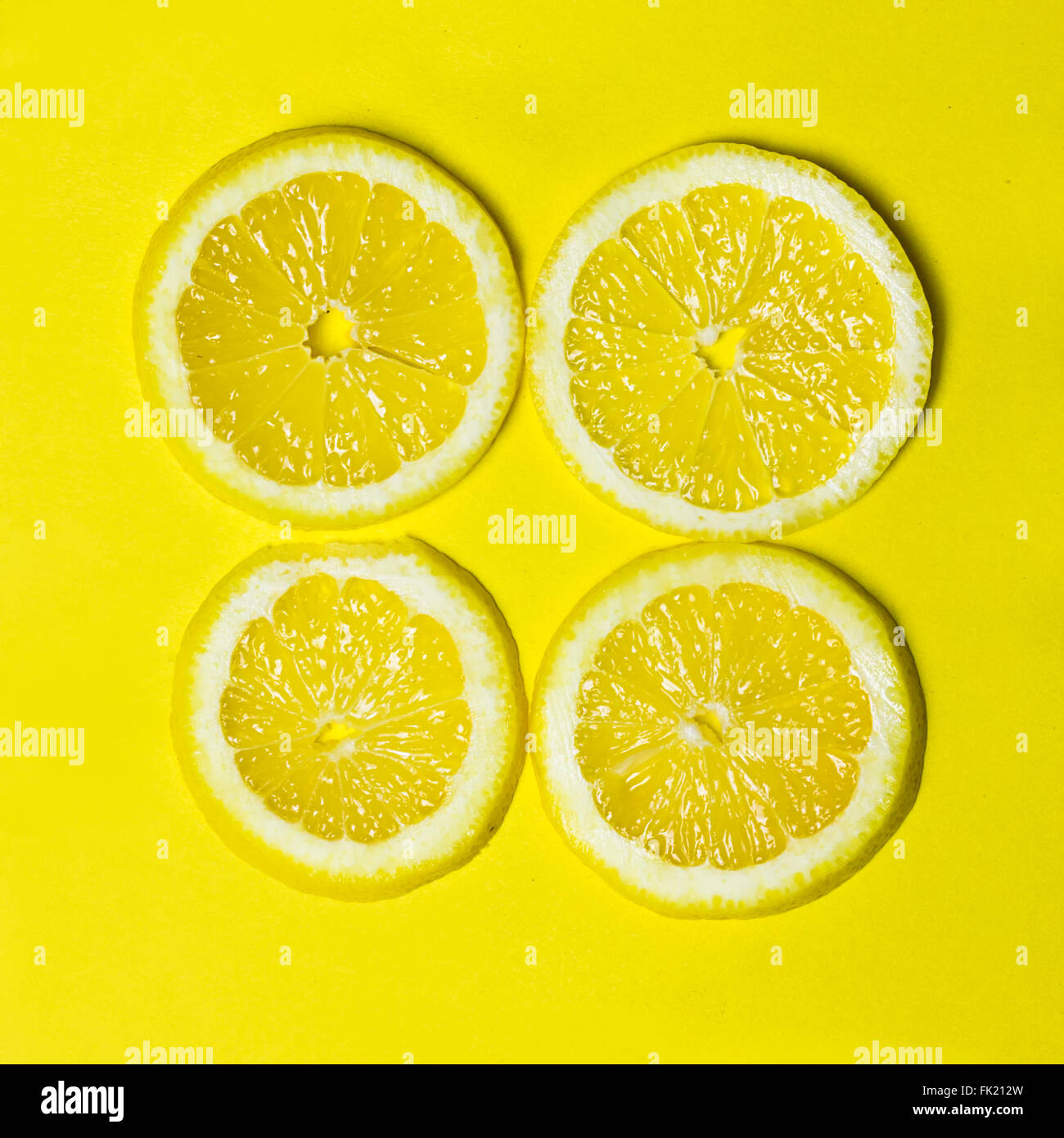 Four Lemon Slices on Yellow Background Stock Photo - Alamy