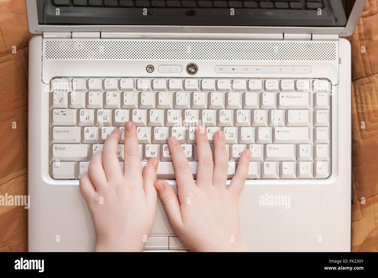 Kid's Hands typing keyboard on desk wood Stock Photo - Alamy