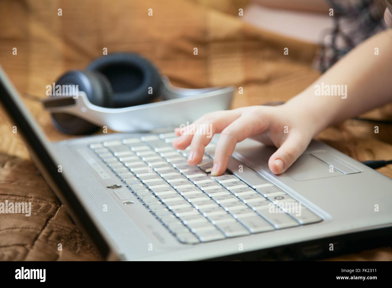 Kid's Hands typing keyboard on desk wood Stock Photo - Alamy