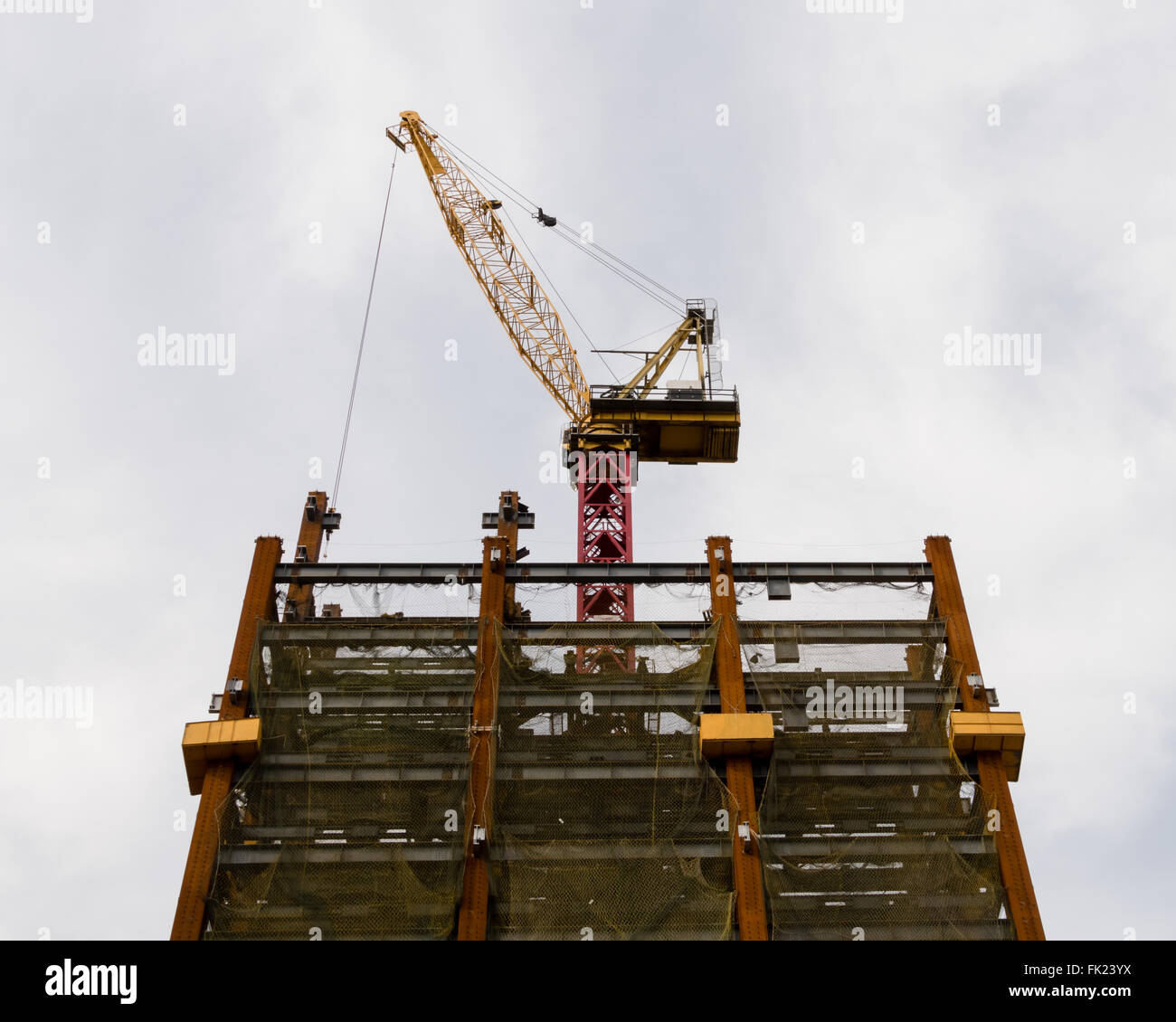 Big building being constructed with crane on top Stock Photo - Alamy