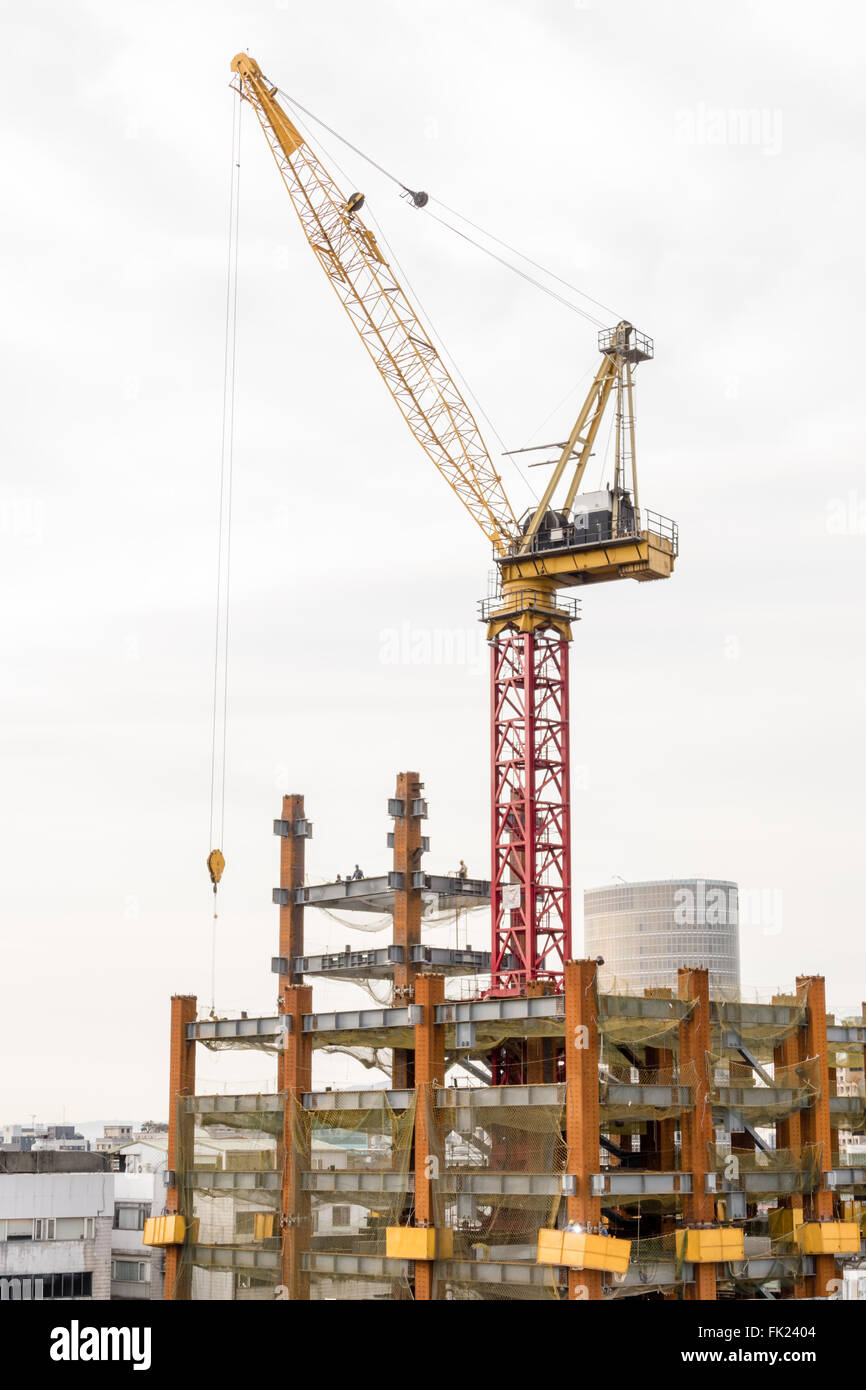 Big building being constructed with crane on top Stock Photo - Alamy