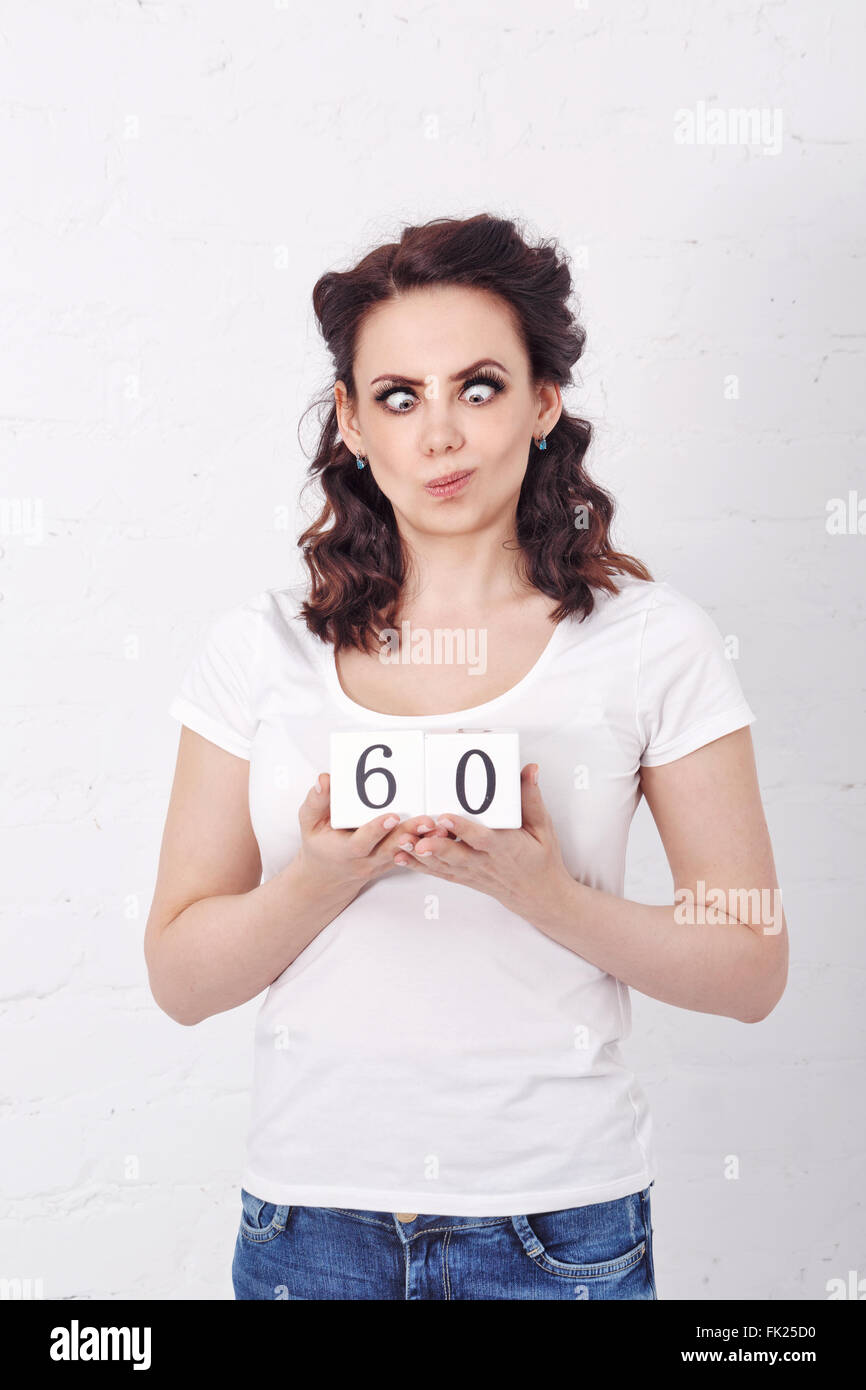 Young cute girl smiling and holding a number sixty hands. Girl dressed ...