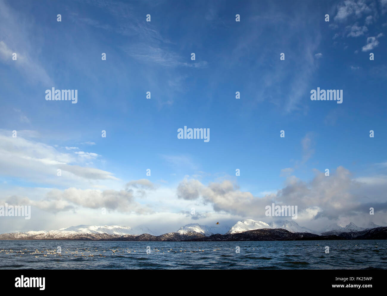 Bright blue sky and interesting clouds over mountains with the Kachemak ...