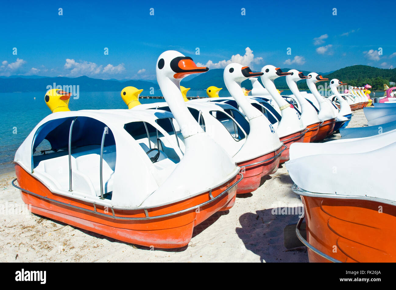 Swan and Winnie The Pooh pedal boats berthed to a pier on Lake Tazawa ...