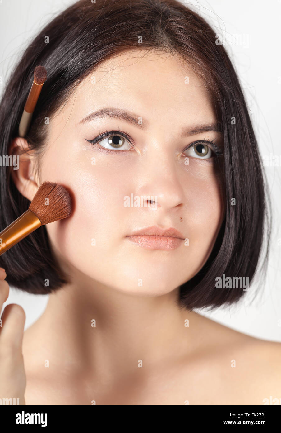 the girl does make-up on a white background Stock Photo - Alamy