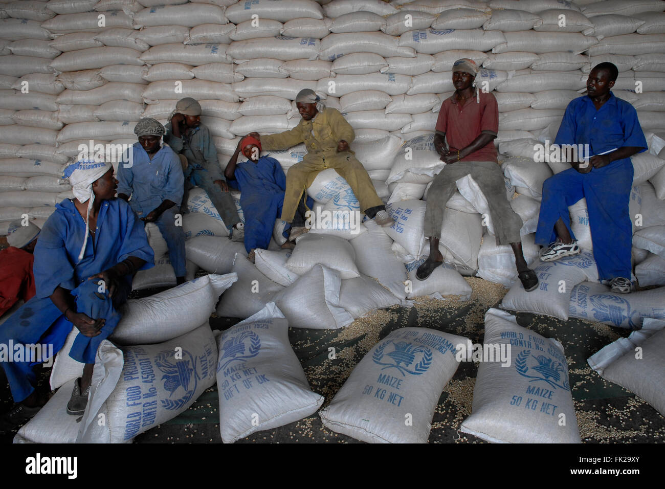 Employees of the World Food Programme WFP sit over large sacks of basic ...