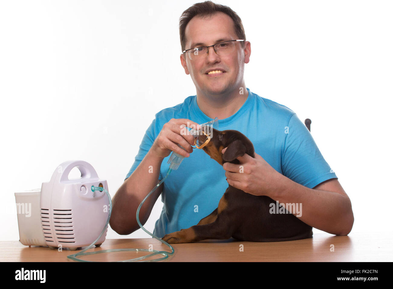 Happy adult doctor using nebulizer mask for respiratory inhaler dog ...