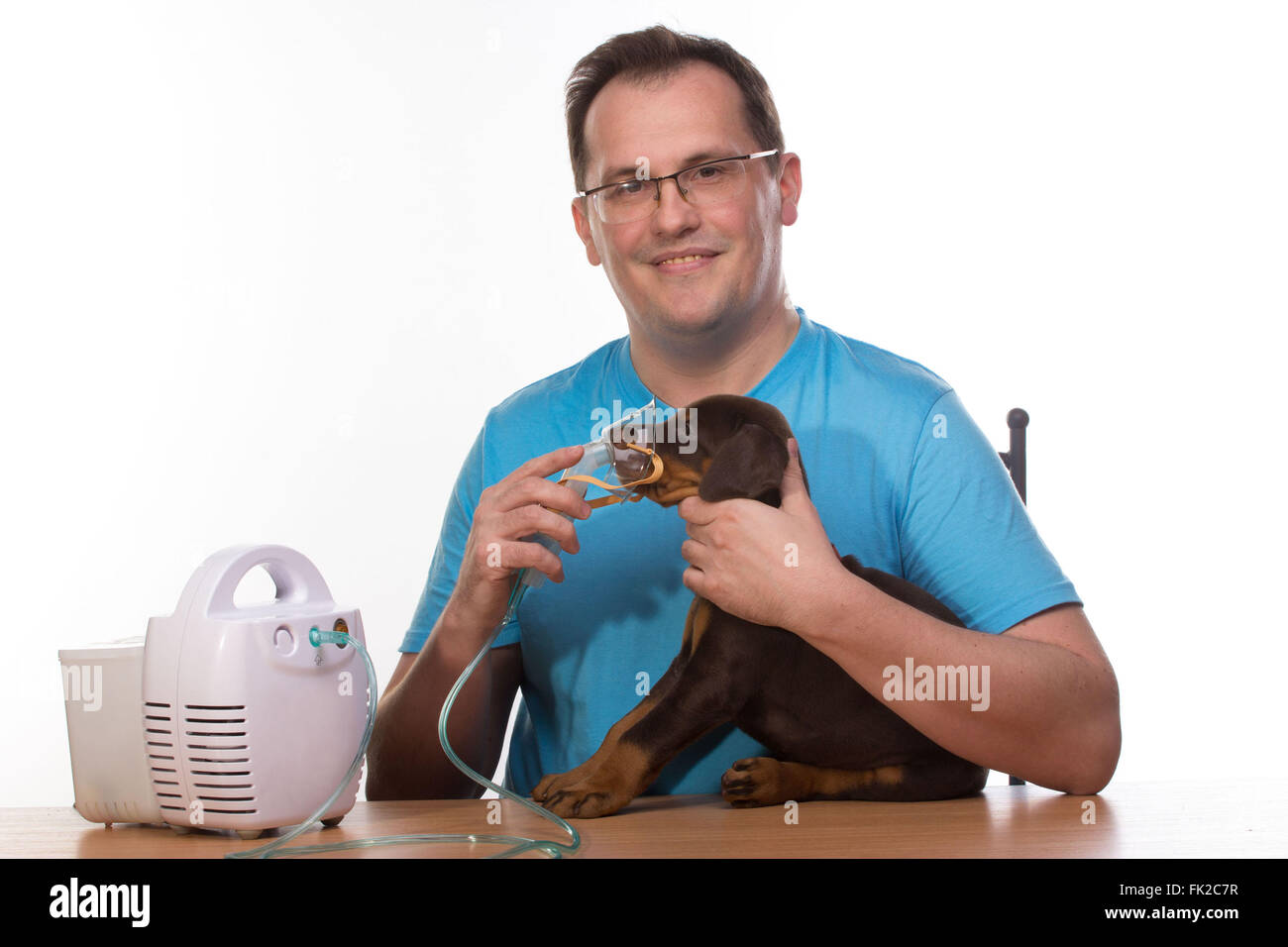Happy adult doctor using nebulizer mask for respiratory inhaler dog ...