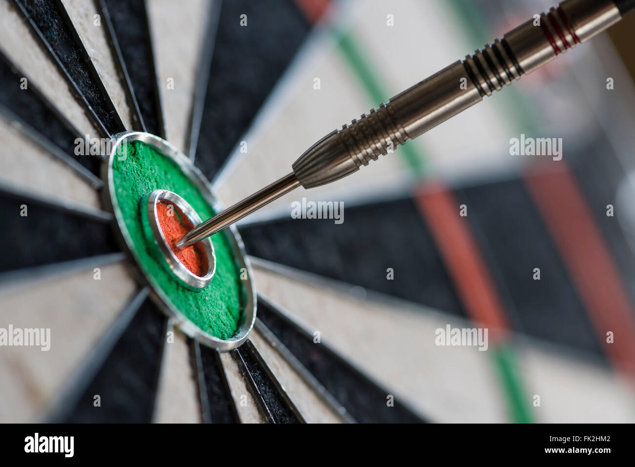 Closeup view of one single dart sticking in the bull's eye of a ...