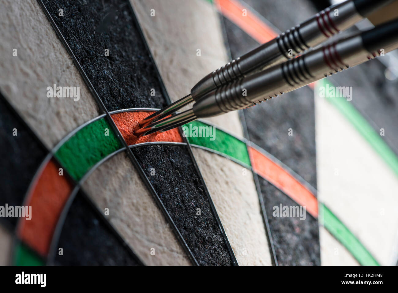 Closeup view of three darts sticking in a professional sisal dartboard ...