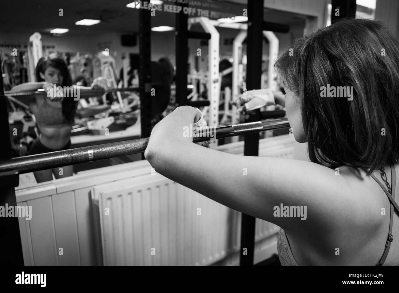 Young and beautiful female fitness competitor on a squats rack Stock ...