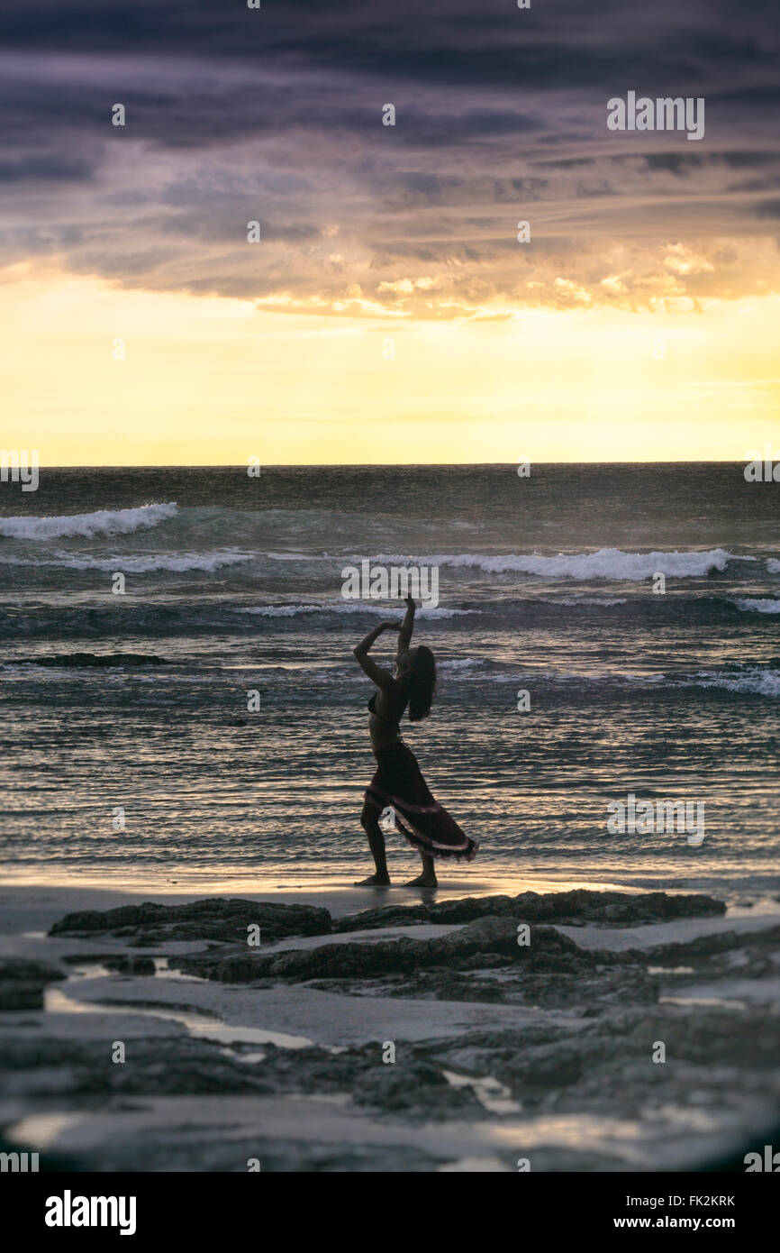 A woman dancing at sunset on a tropical beach Stock Photo - Alamy