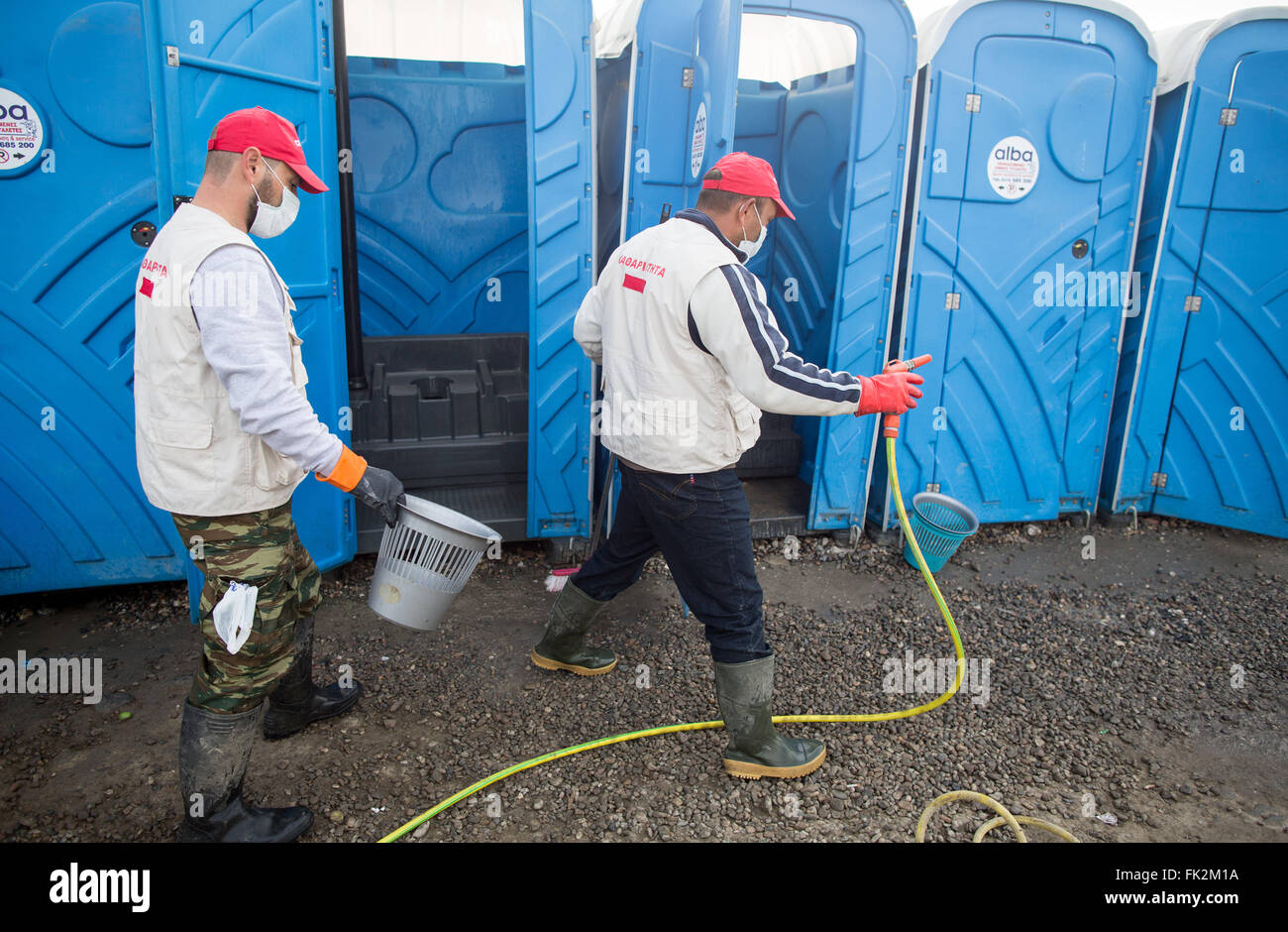 Helpers clean the toilets in the refugee camp near the Greek-Macedonian ...